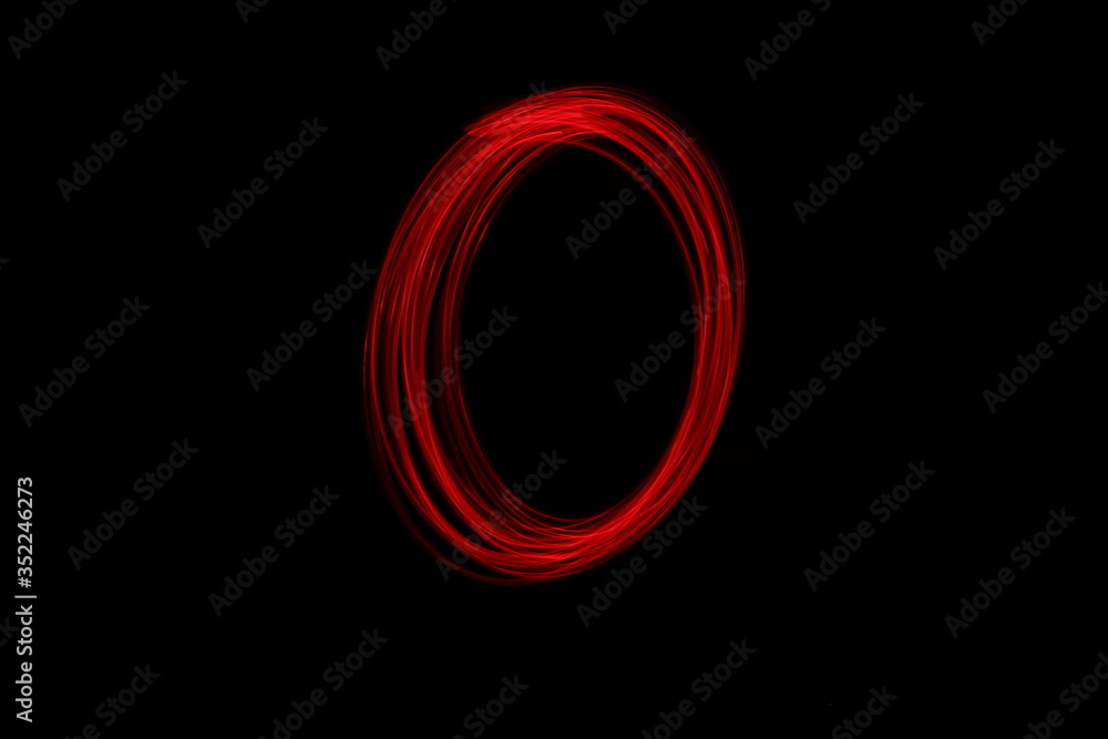 Long exposure photograph of the letter o in neon red colour fairy ...