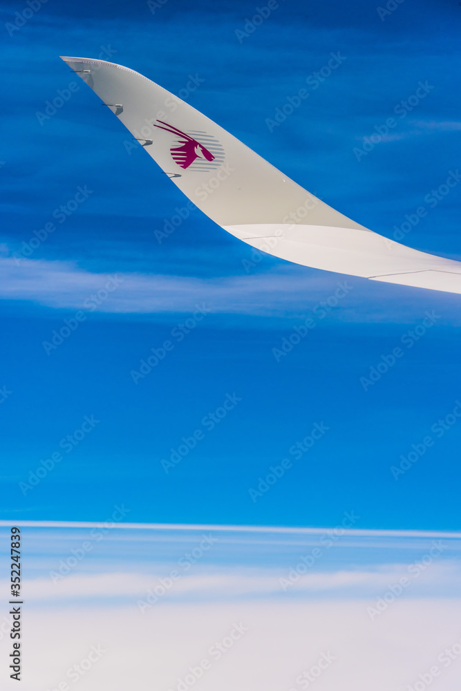 Aircraft wing with the Qatar Airways logo over the blue sky Stock Photo ...