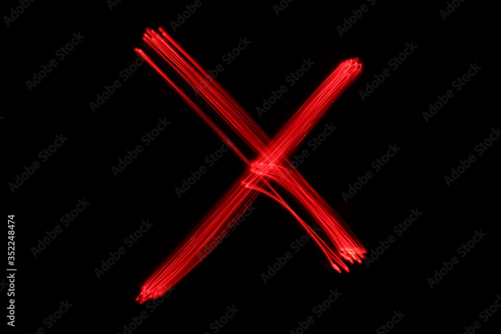 Long exposure photograph of the letter x in neon red colour fairy ...