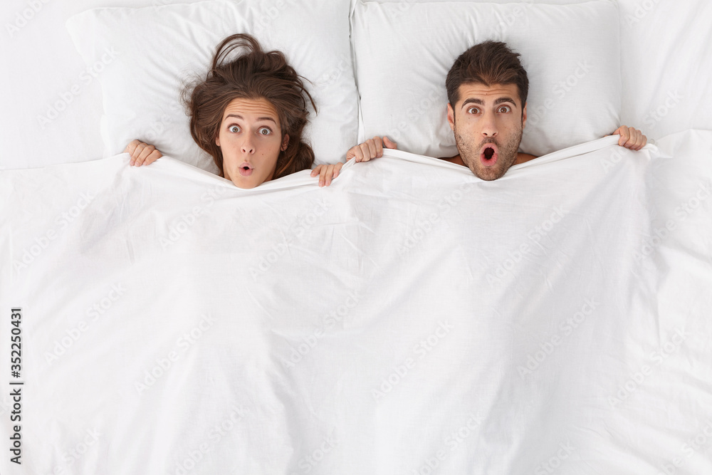 Foto de Scared frightened woman and man couple feel fear after awake ...