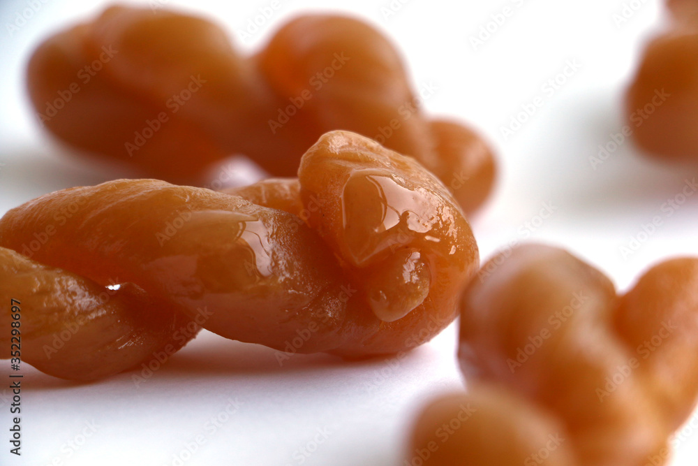 Traditional South African sweet koeksisters covered in syrup, isolated ...