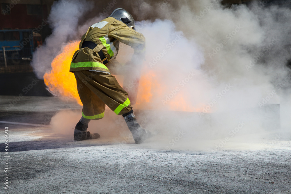 A professional fireman in a special suit jumps over a barrier .Regional ...