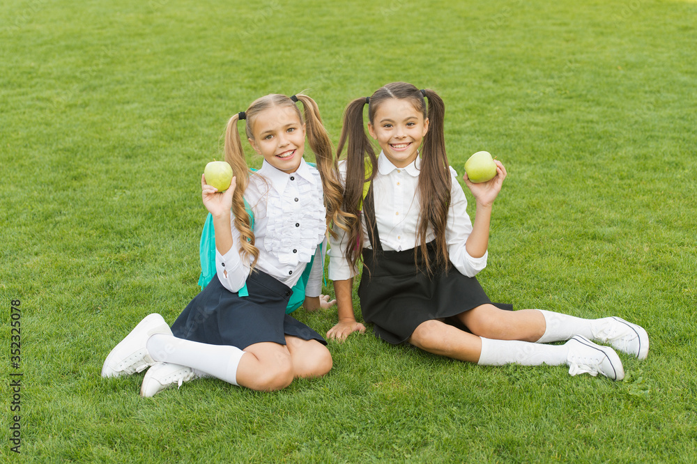 Meal break can be fun. Happy kids hold apples on green grass. Little ...