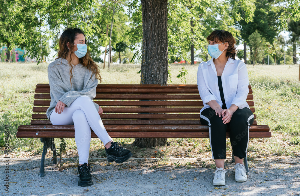 Social distance. Mother and daughter in social distance sitting on a ...