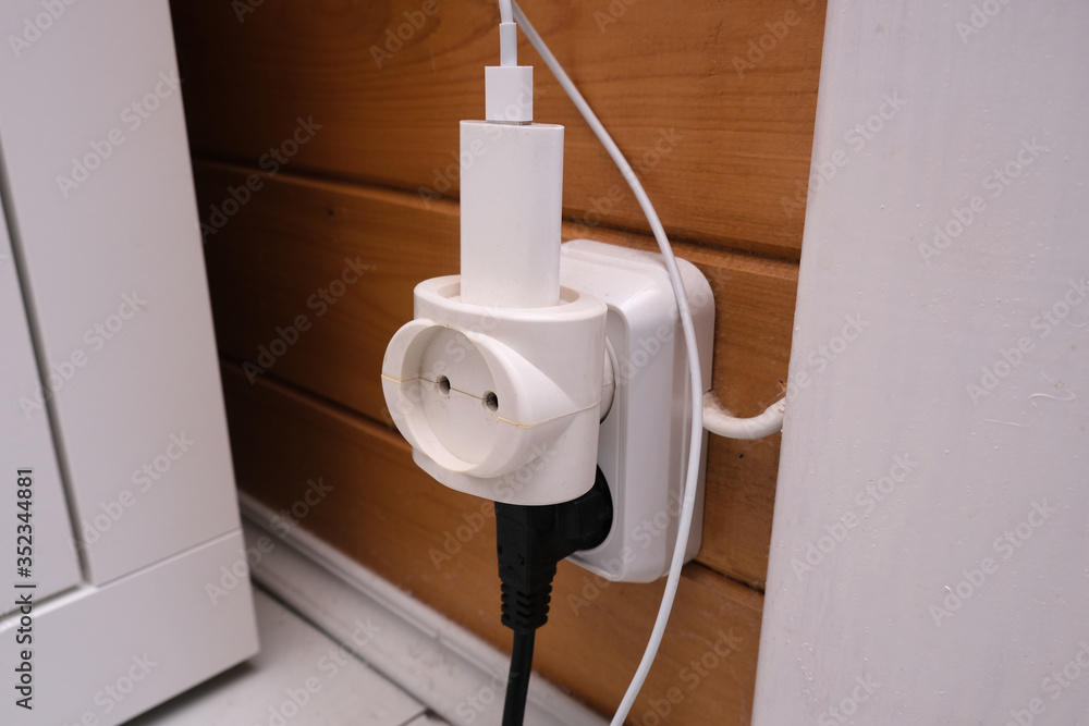 Overloaded outlet with an extension and many sockets plugged in and one ...