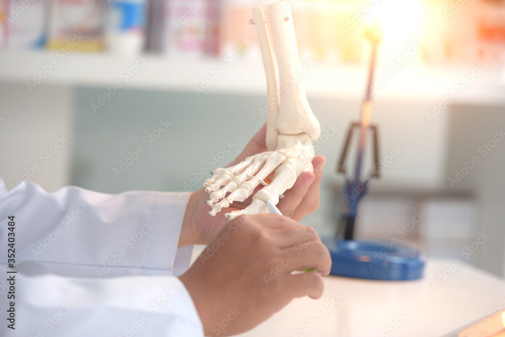 Orthopedic doctor in his office with the patient and the foot model ...