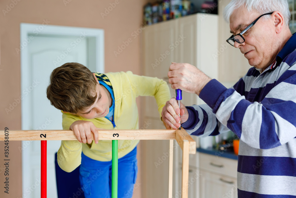 Little kid boy and grandfather working and constructing and repairing ...