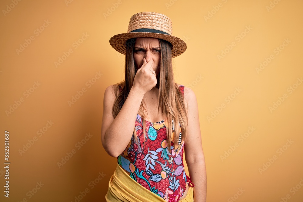 Young beautiful blonde woman wearing swimsuit and summer hat over ...