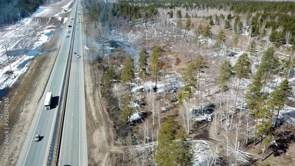 cars go along the highway near the forest. The forest is burning. fire ...