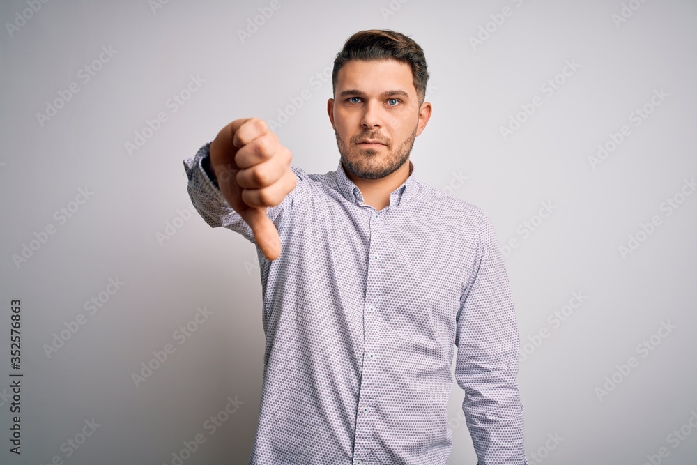 Young business man with blue eyes standing over isolated background ...