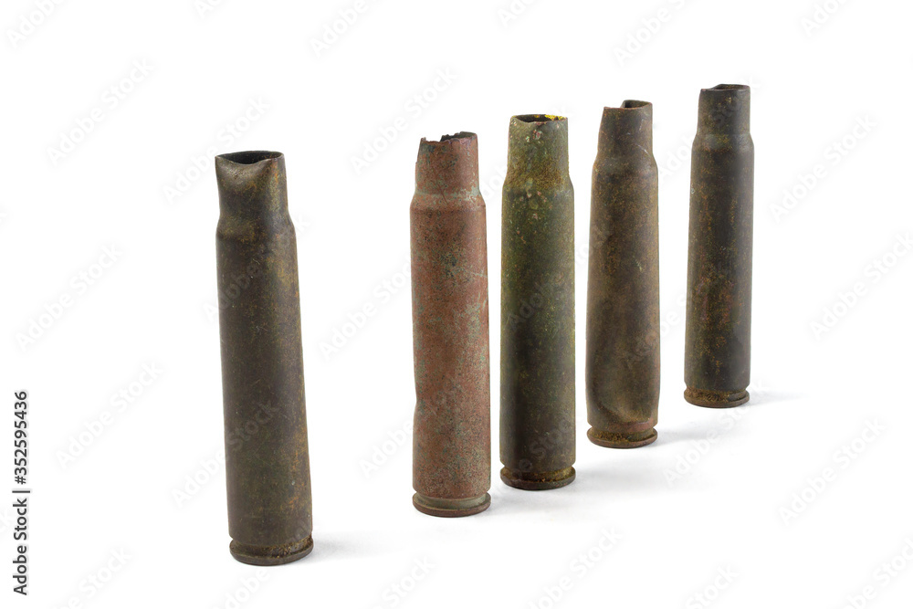 old used weapon shells from World War II stand. rusty, moss, on a white ...