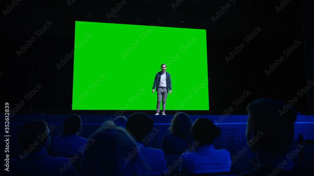 On Stage, Keynote Speaker Presents New Product to the Audience, Behind ...