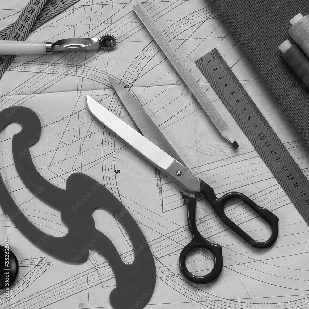 on a paper pattern are tailor's scissors, a pattern, a ruler, a pencil ...