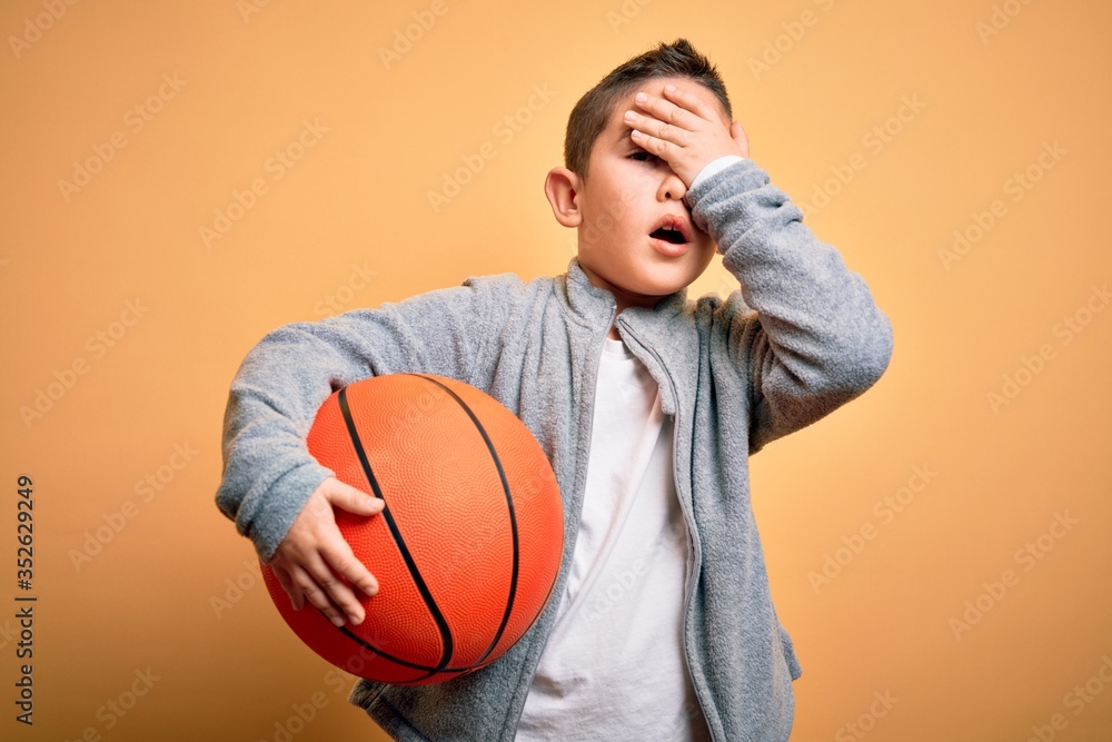 Young little boy kid playing with basketball game ball over isolated ...