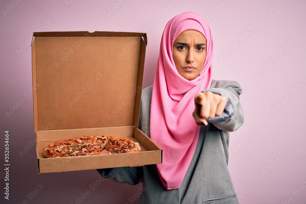 Young beautiful arab woman wearing pink muslim hijab holding delivery ...