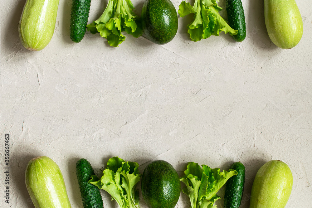 Assortment of fresh green organic vegetables on a concrete background ...