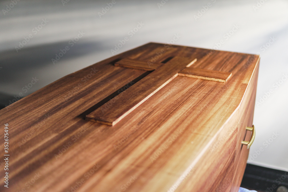 Coffin, funerary wooden brown box in an empty room. Might be in a ...