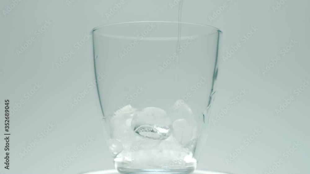 Man puts ice cubes and pouring sweet soda water of brown color from a ...