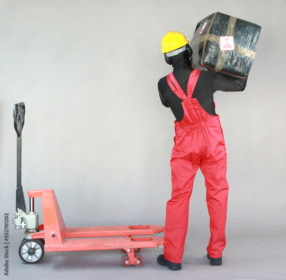 Anonymous worker dealing with heavy package at manual pallet truck ...