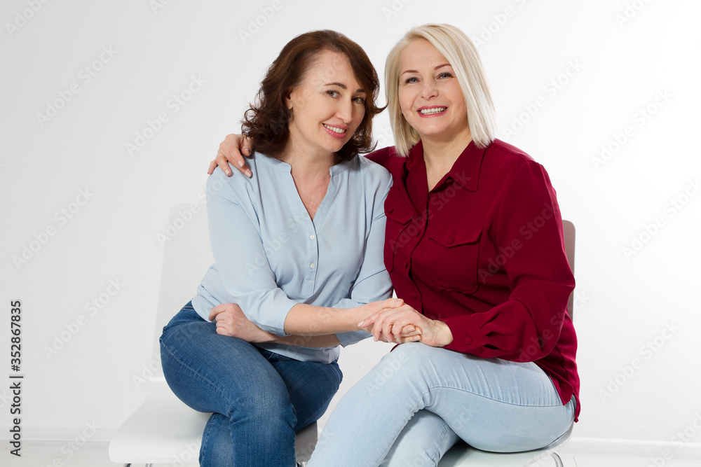 Two middle aged women talking. Isolated white background. Women support ...