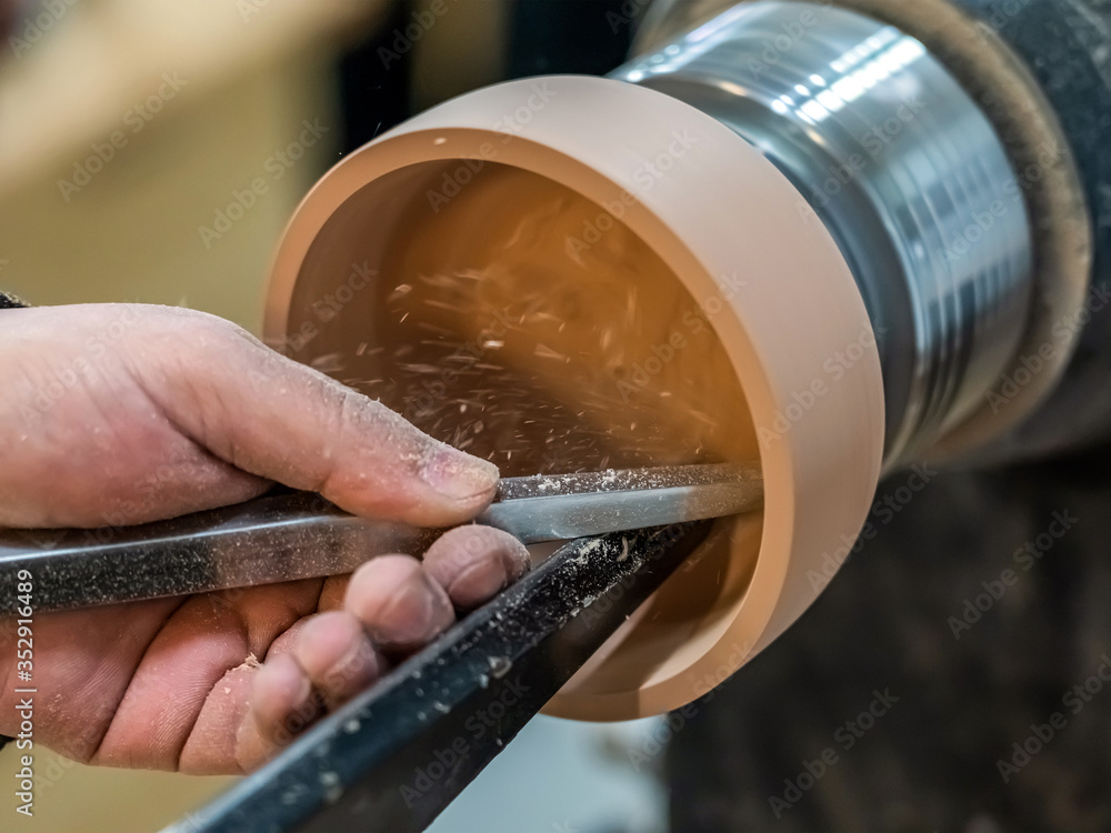 Carpenter man is shaving the wooden bowl. Spinning wood wheel. Carving ...