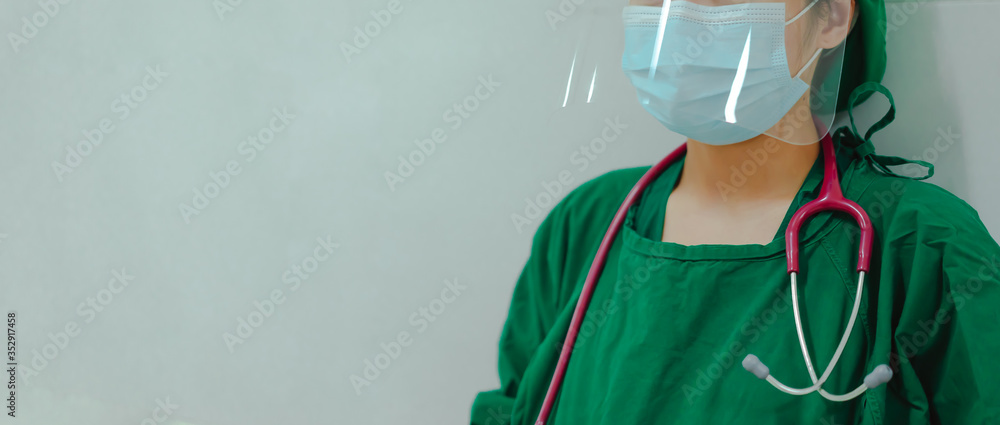 Asian female nurse wears surgical masks, green gown, face shield, and a ...