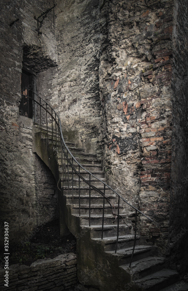 An old medieval circual staircase with an iron metal balustrade leading ...