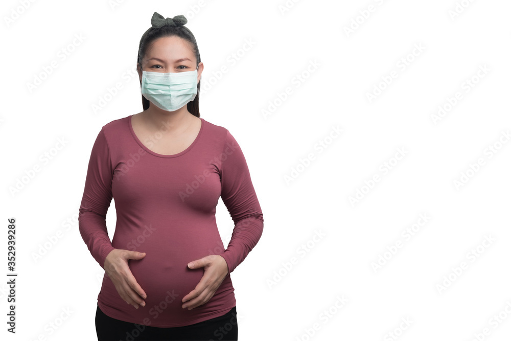 Asian pregnant woman wearing surgical mask looking at camera and ...