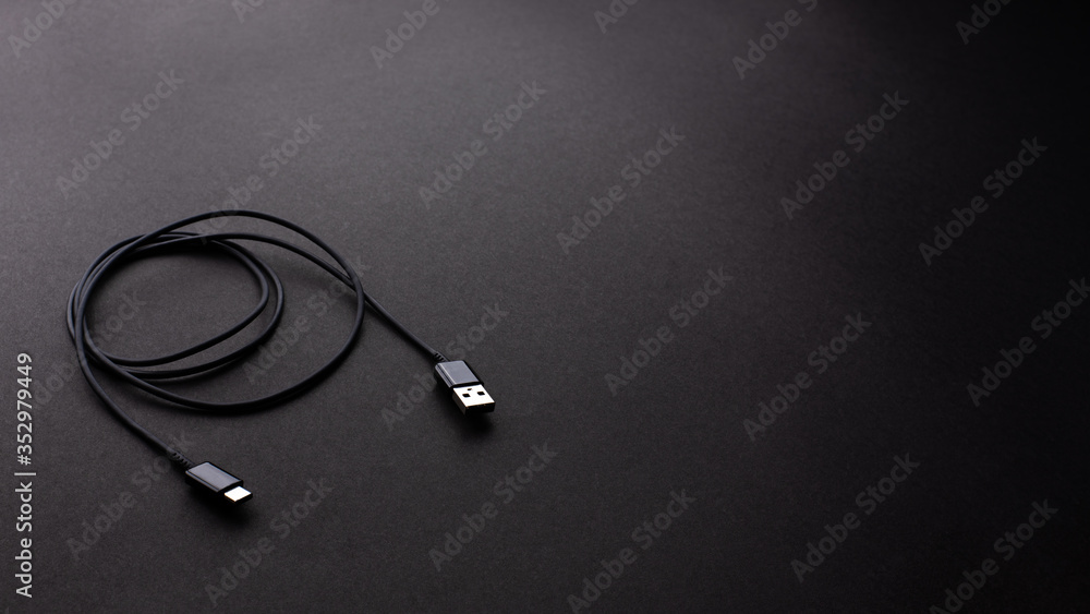 Black usb cable on black texture background, office desk table from top ...