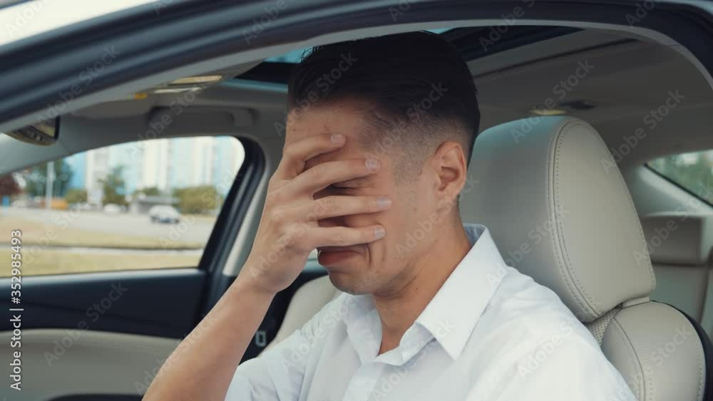 Sad male businessman crying while sitting in a car. Crisis and problems ...