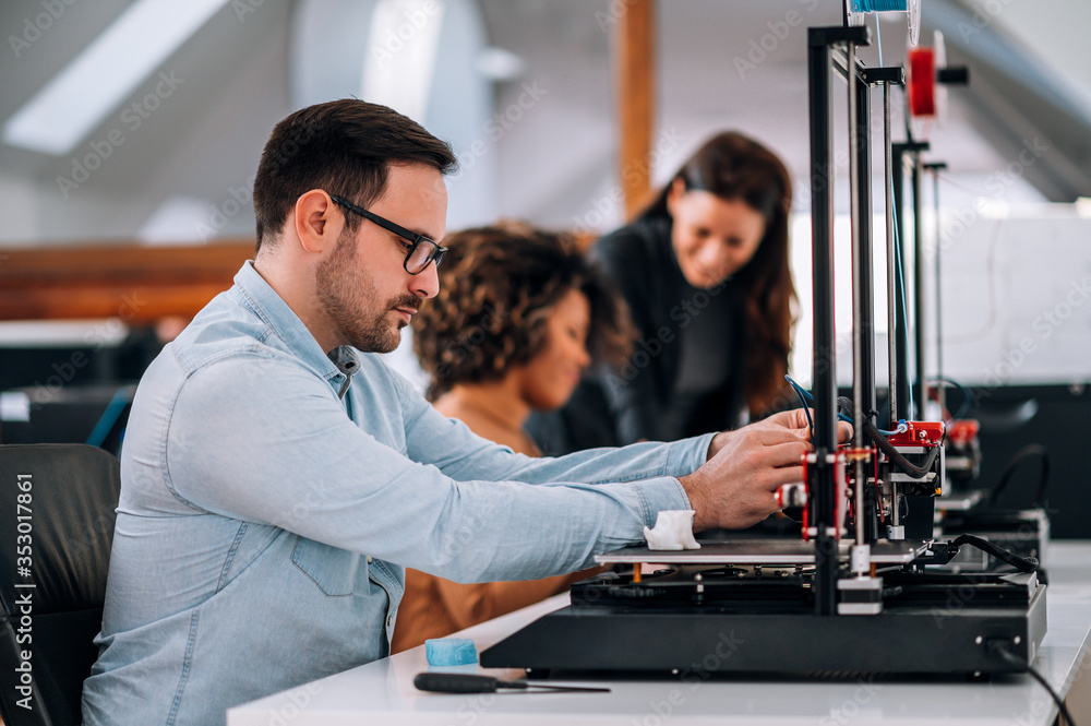 Side view portrait of a handsome man working with 3D printer. Stock ...
