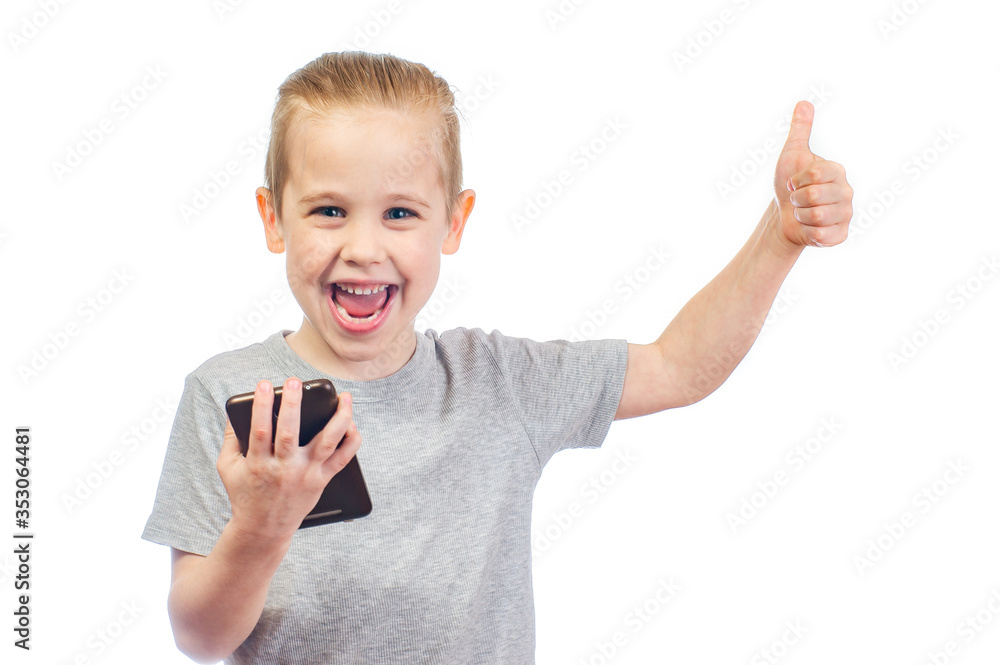 Young smiling caucasian boy with mobile phone shows thumbs up isolated ...