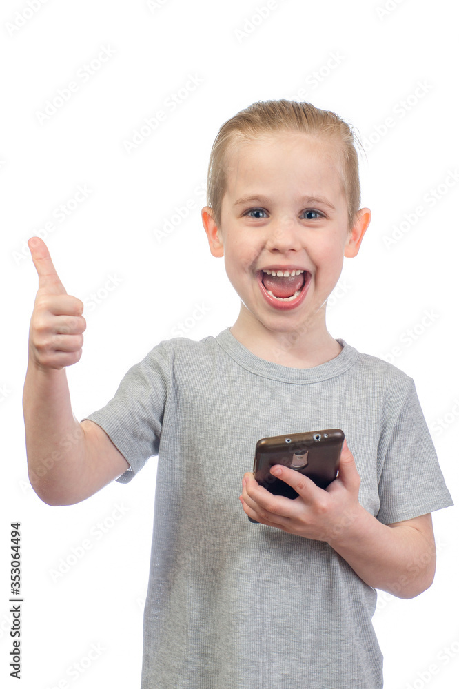 Young smiling caucasian boy with mobile phone shows thumbs up isolated ...