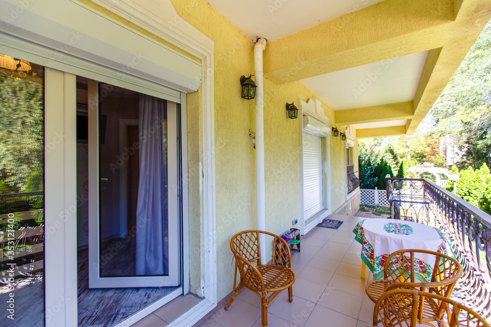 Verandah with wicker furniture and iron railings on the first floor of ...