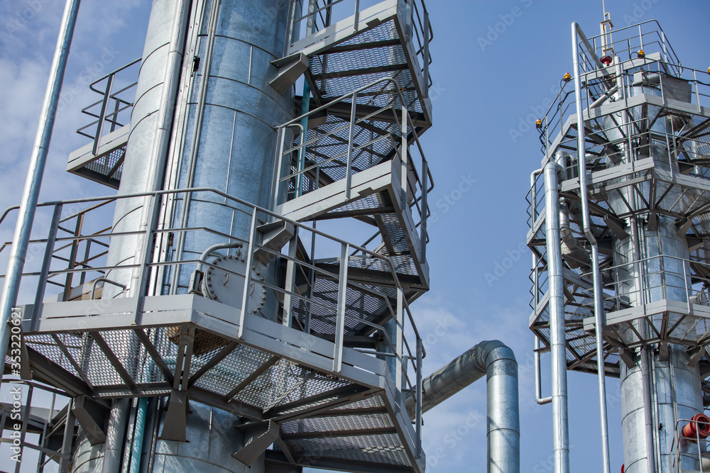 Fractional distillation towers (refining columns). Blue sky background ...