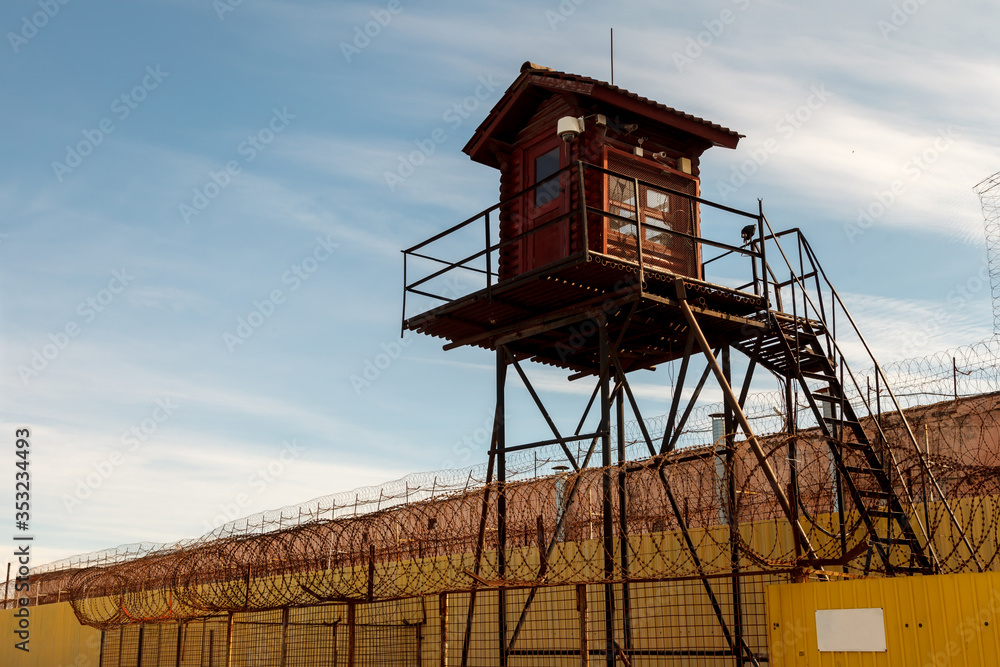 Prison tower and barbed wire fence. Wooden tower with room for guard of ...