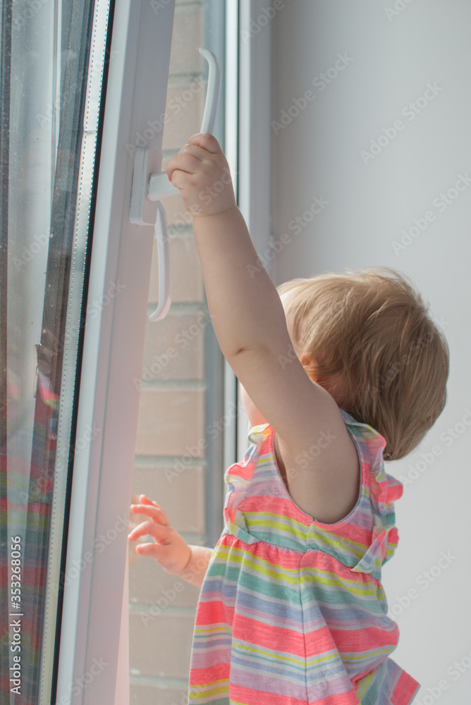 Little girl opens the window. Children safety at home. Prevention of ...