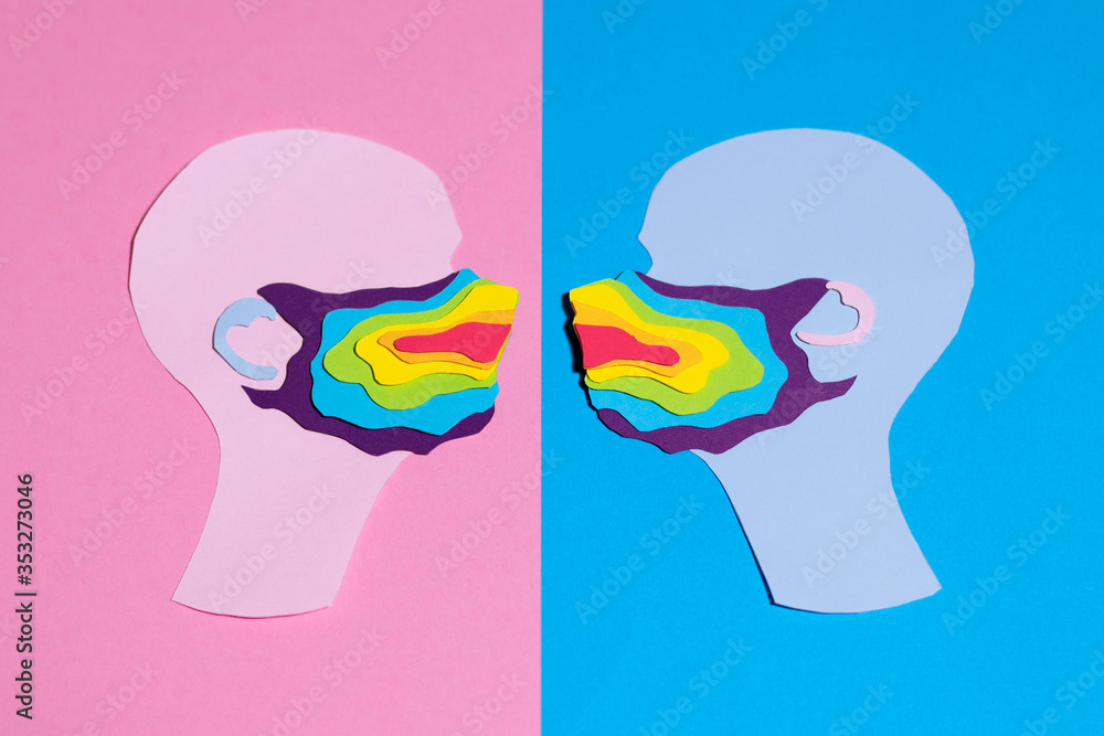 Two human profiles in rainbow masks cut out of paper look at each other ...