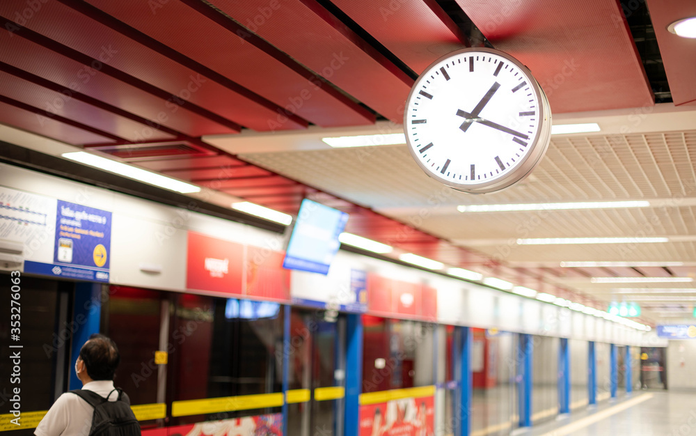 A classic white digital clock and escape exit sign hang from the ...