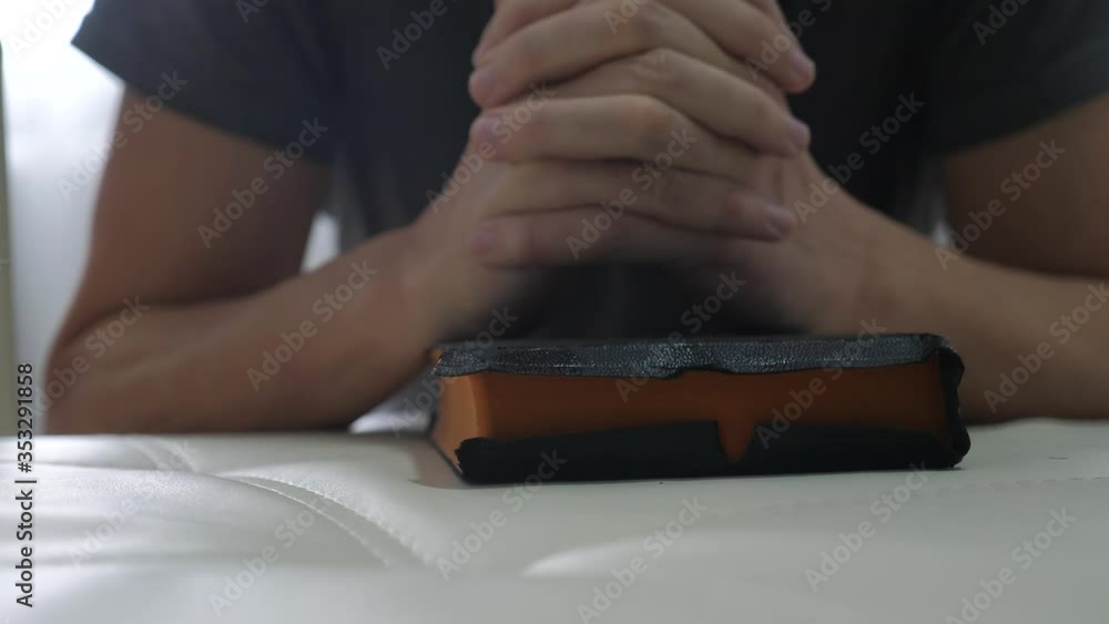 man praying indoors at bedtime on bible. religion concept evening ...