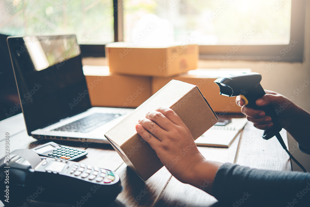 Delivery staff scanning cardboard box with barcode scanner to check ...