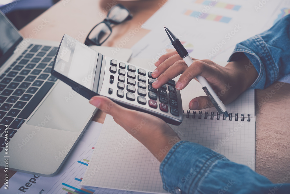 The accountant's hand is using the calculator. For cost analysis Profit ...