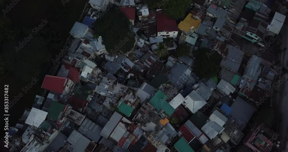 Contrast aerial flight of poor housing area, Tilt up to reveal ...