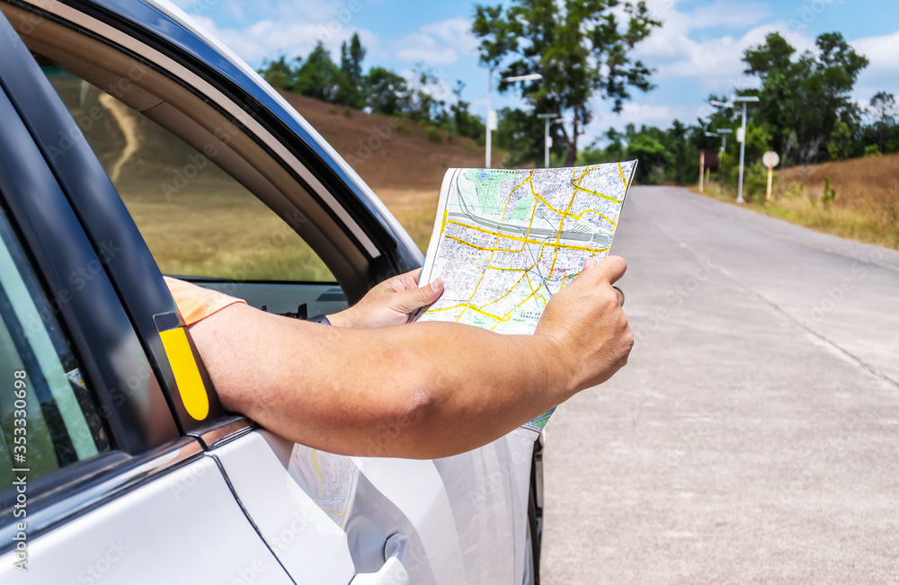 Road trip, Traveler man on vacation looking at map for directions while ...