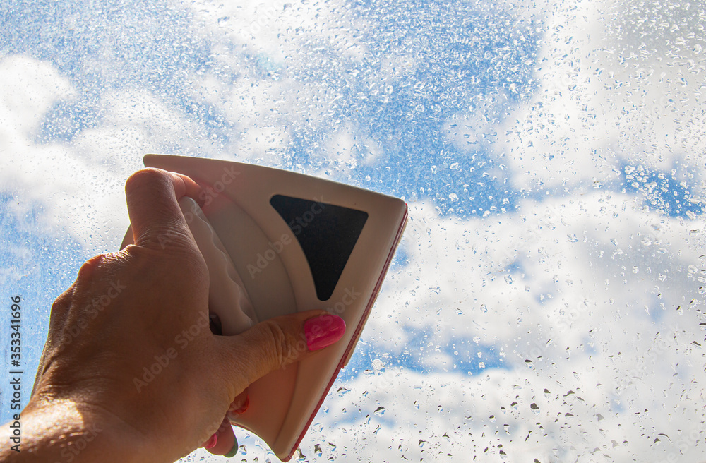 woman hand washing cleaning windows with a modern magnetic brush ...