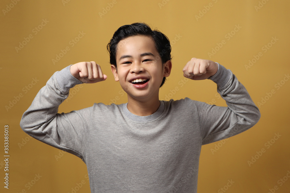 Portrait of funny strong healthy Asian boy shows his muscle and ...