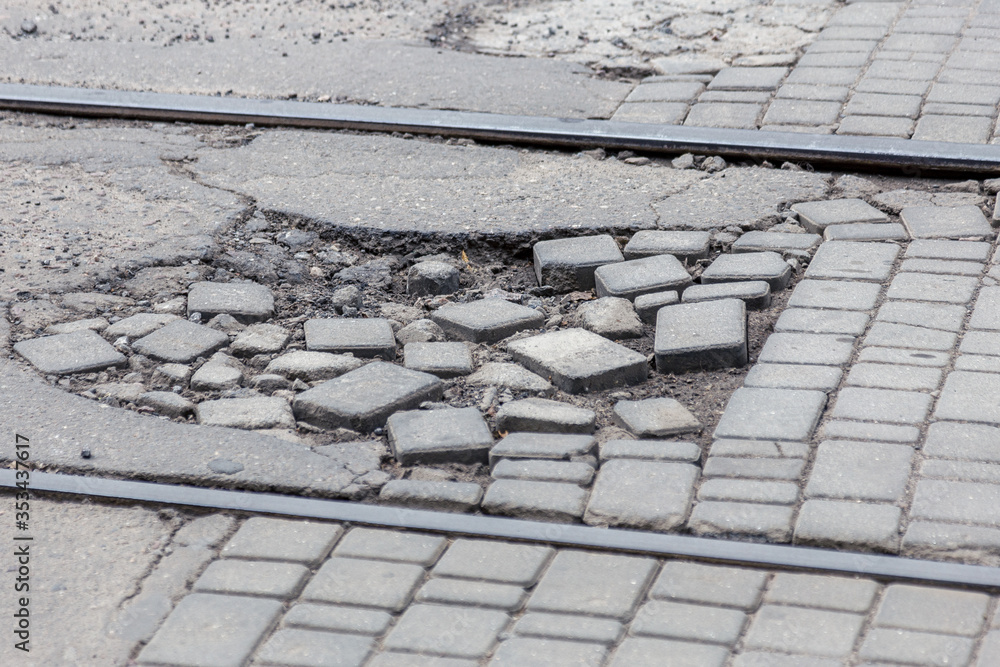 Damaged road with potholes, caused by freeze-thaw cycles in winter. Bad ...