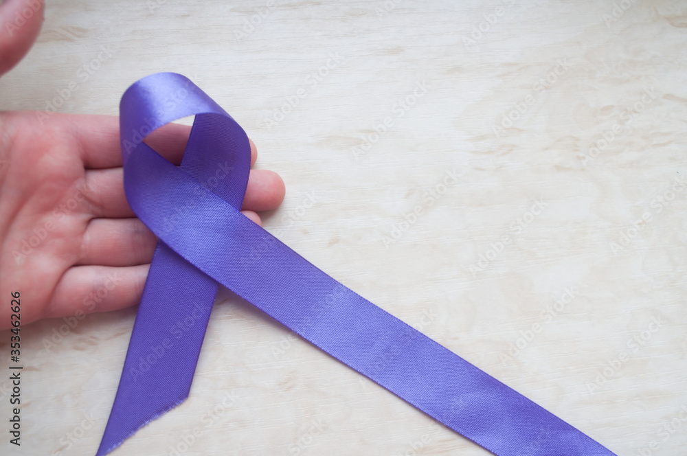 hand holds a purple awareness ribbon. World Lupus Day. Autoimmune ...