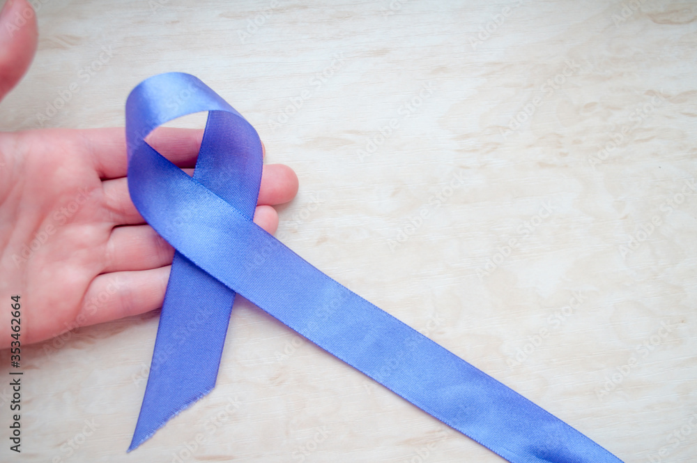 hand holds purple awareness ribbon. World cancer day. World Lupus Day ...