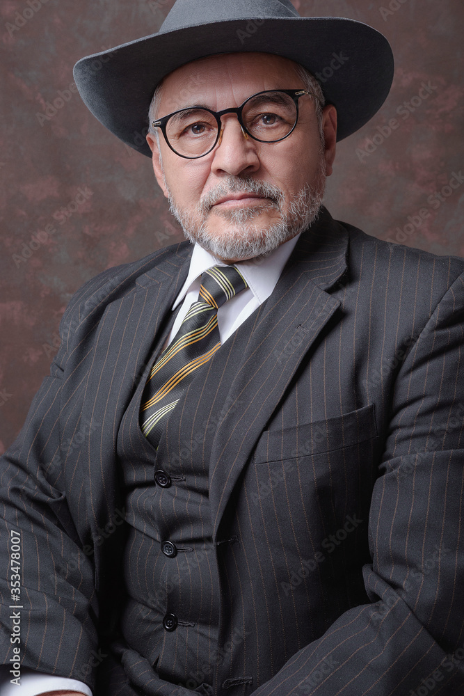 Señor maduro posando para la cámara con un traje de color café oscuro ...